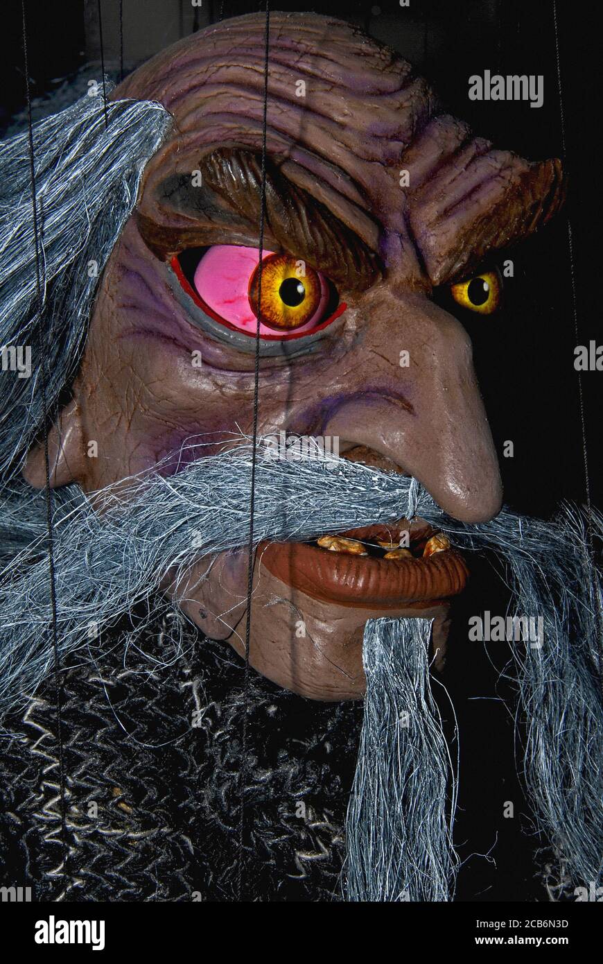 Wooden wizard puppet with pink and yellow bloodshot eyes, rotting teeth ...