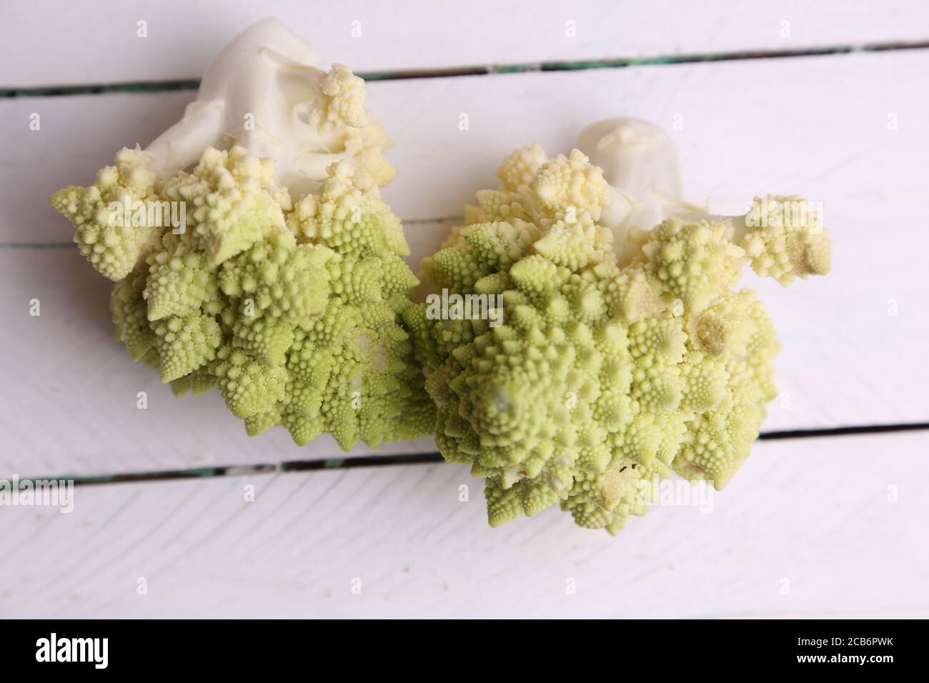 High angle shot of some fresh broccoli isolated on a white wooden ...