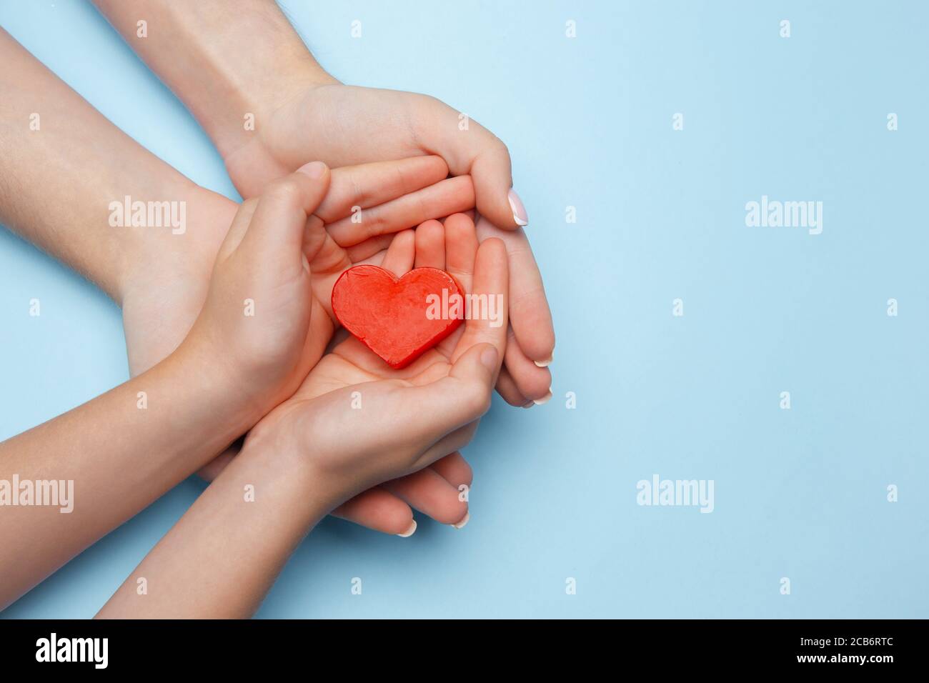 Human hands holding, giving heart isolated on blue background with ...