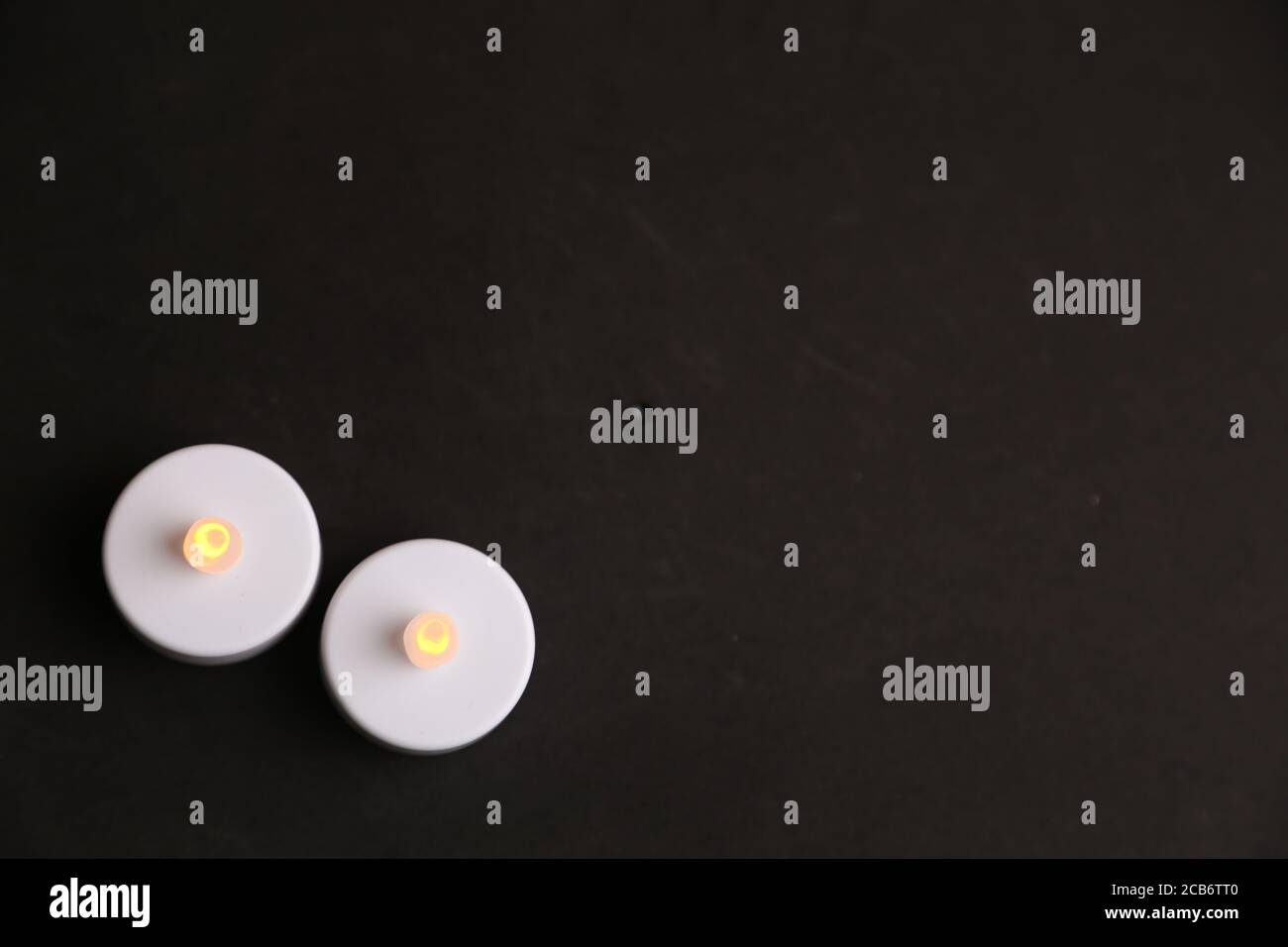 Overhead shot of white plastic led candles on a black surface Stock ...