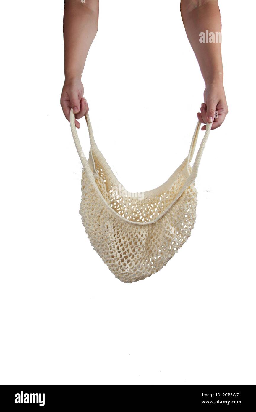 string bag against white background in woman's hands. Image contains ...
