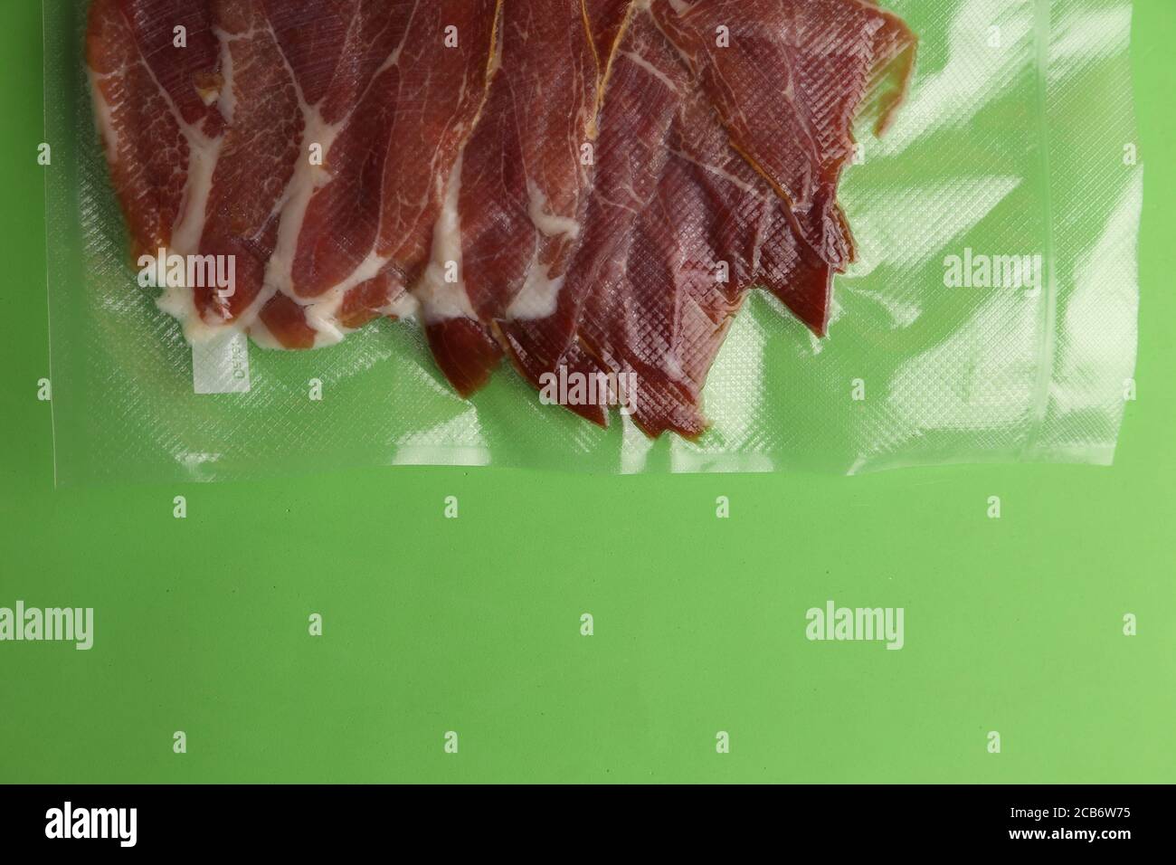 Overhead shot of raw beef meat in a plastic bag on a monochrome ...