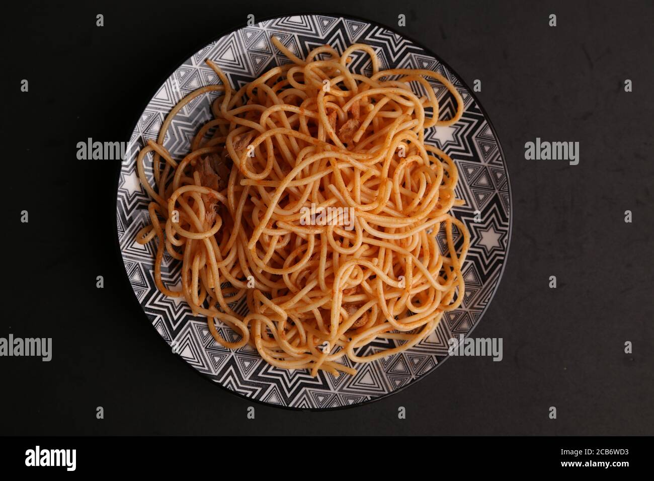 High angle shot of a plate of delicious spaghetti isolated on a black ...