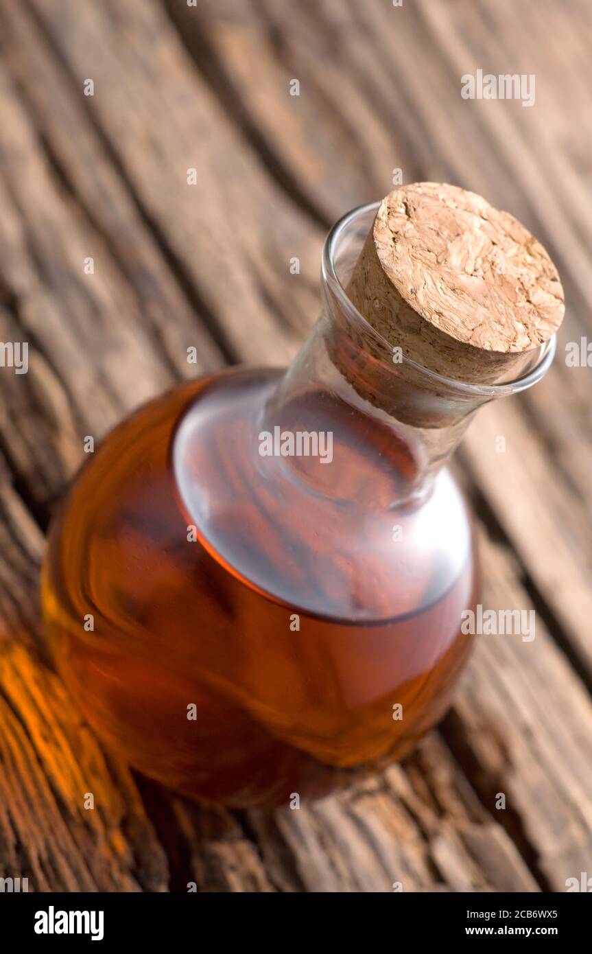 Glass flacon with oil on old wood Stock Photo - Alamy