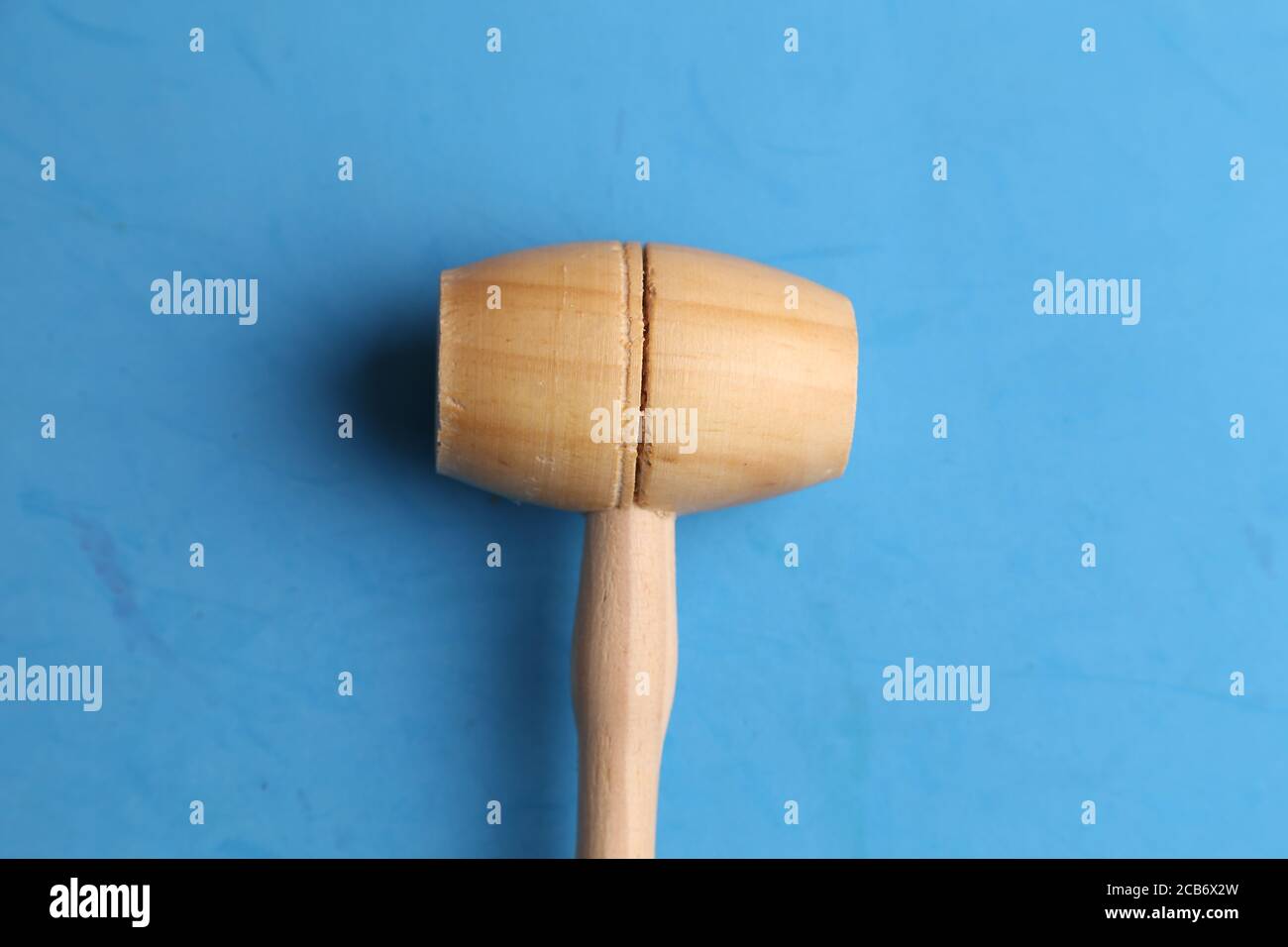 Top view of a small round-headed wooden mallet on blue background Stock ...