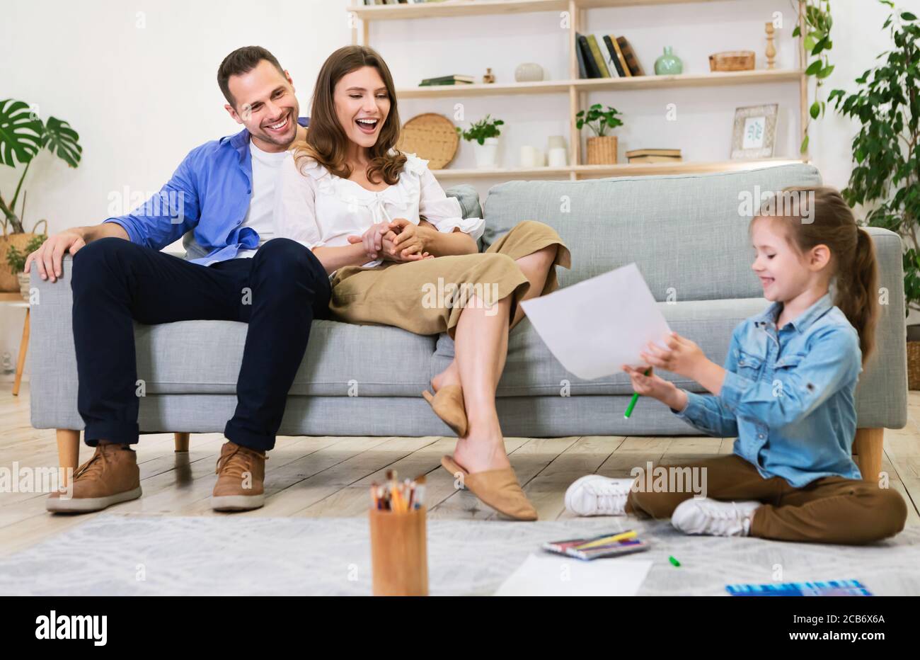 Little Daughter Showing Her Drawing To Parents At Home Stock Photo - Alamy