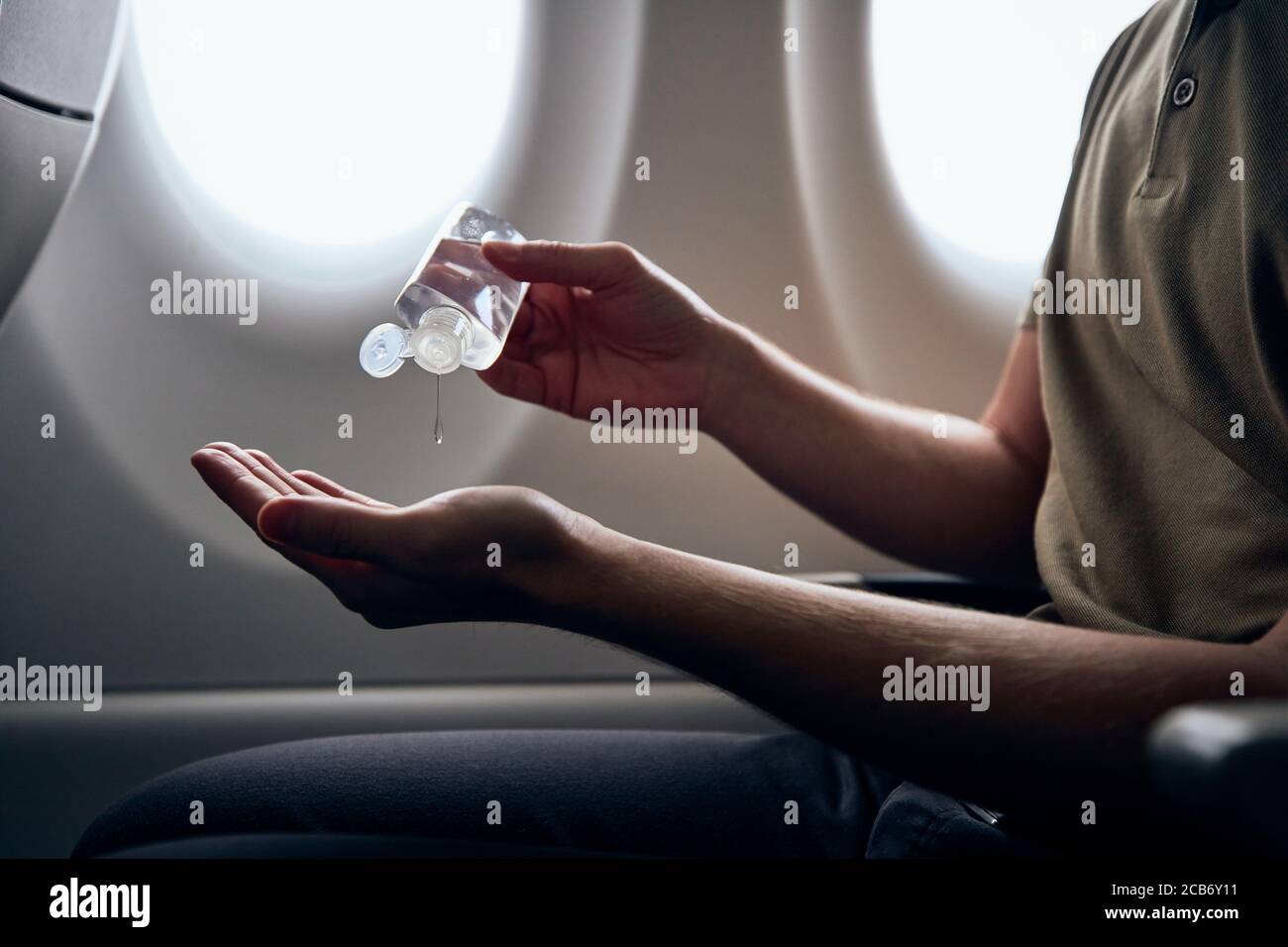 Man using hand sanitizer inside airplane during flight. Themes new ...