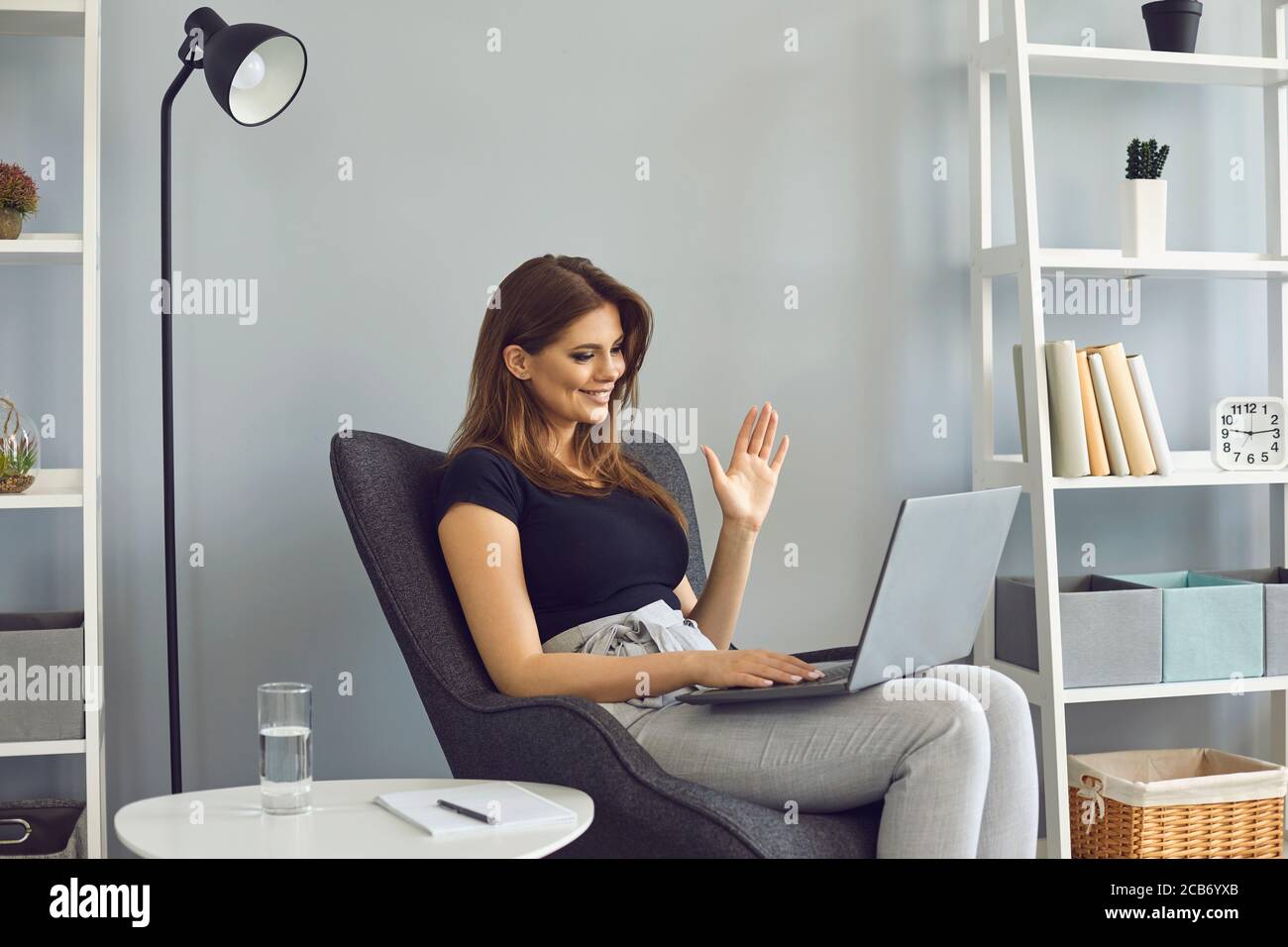 Woman waving hand has video call laptop computer online sitting in ...