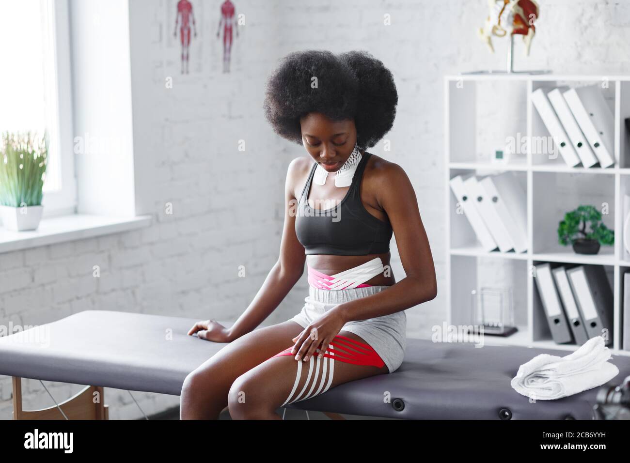 Young female African American athlete visiting physiotherapist ...