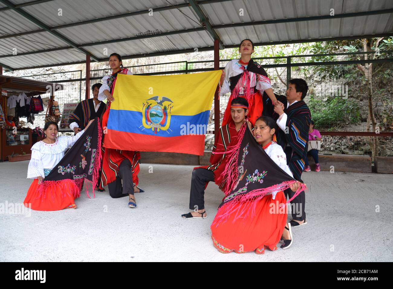Ecuadorian native people in traditional clothes holds the national flag ...