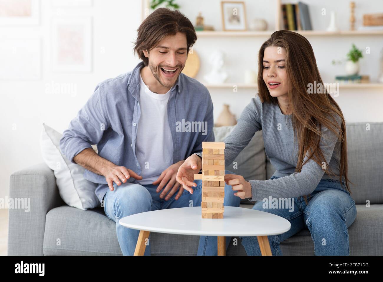 Couple playing Jenga while sitting in the living room Stock Photo - Alamy