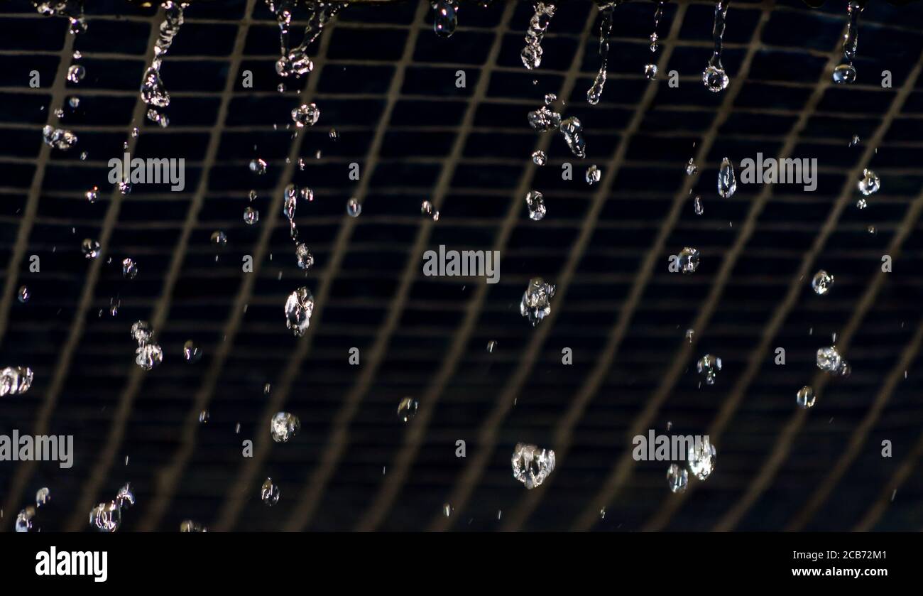 falling water drops from wall with vintage tiles close up abstract ...