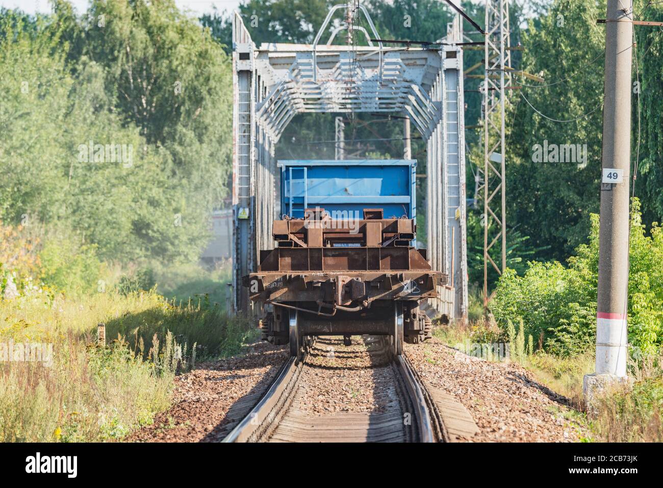 Freight train moves through the bridge at summer day time Stock Photo ...