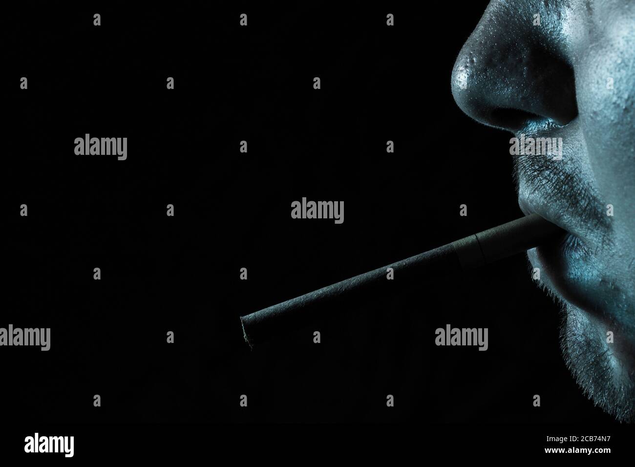 part of the face with a cigarette in the mouth closeup warning about ...