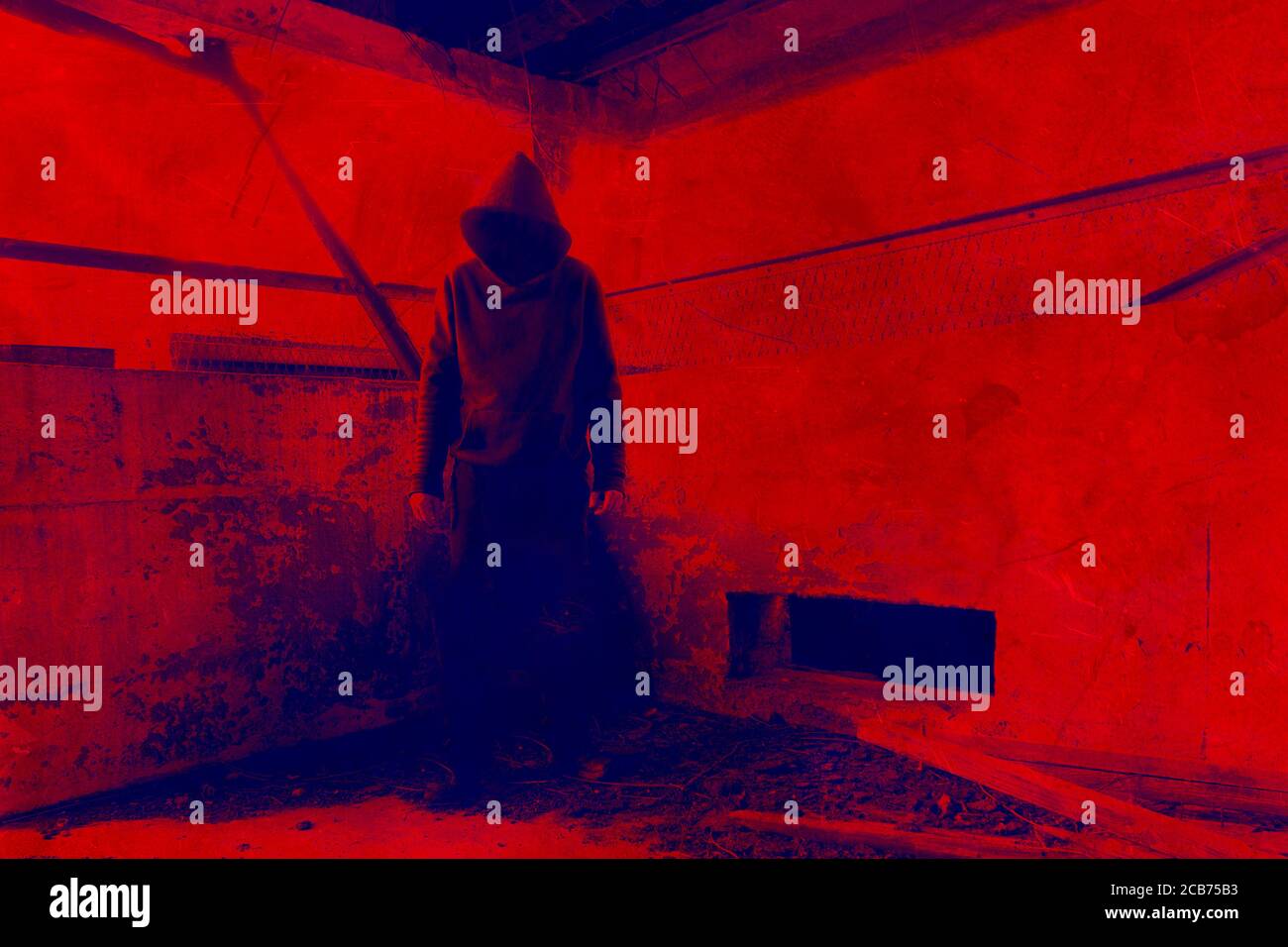 A duo tone horror concept. A scary hooded figure standing in a ruined ...
