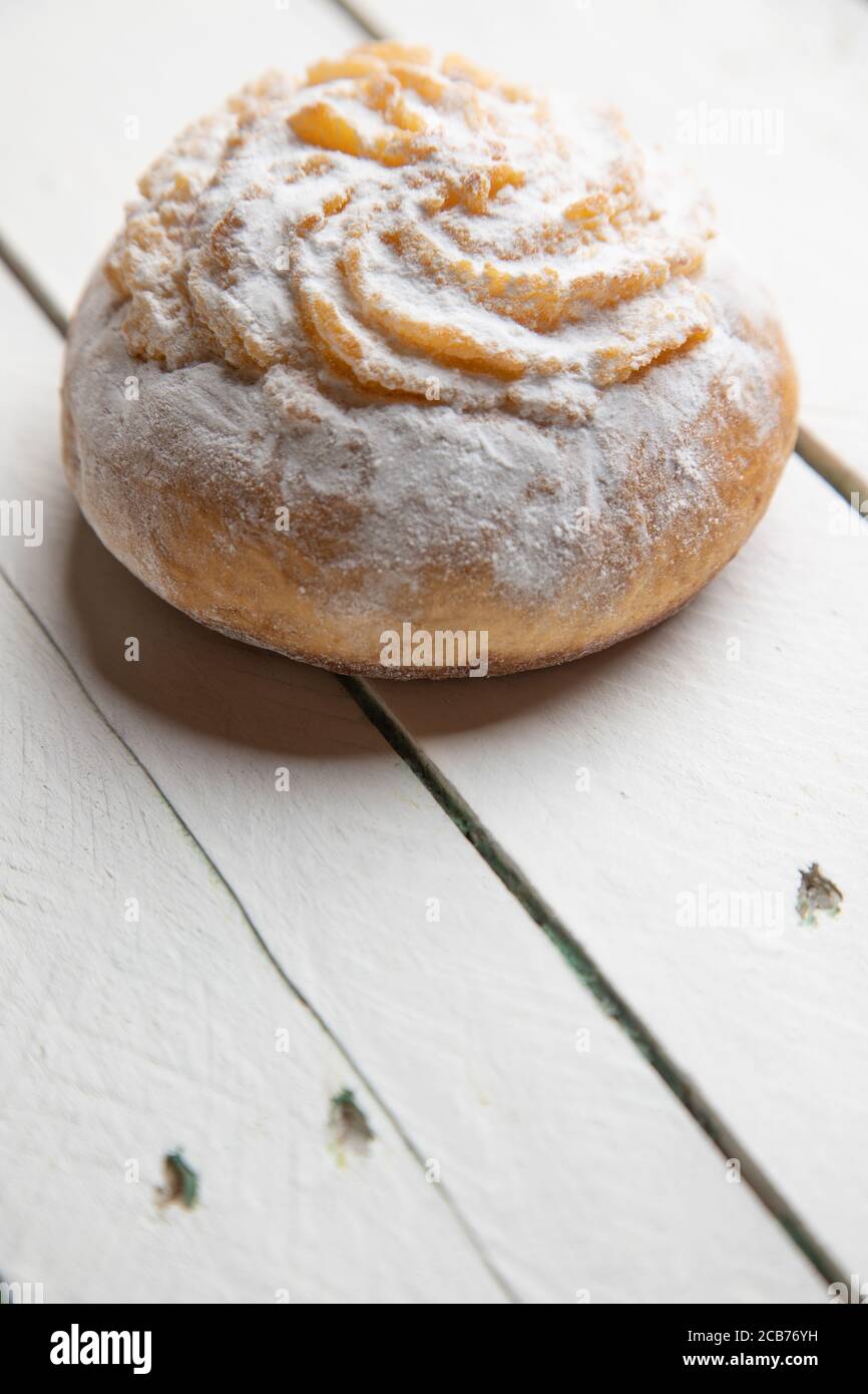 Vertical shot of a fresh bun on a white timber table Stock Photo - Alamy