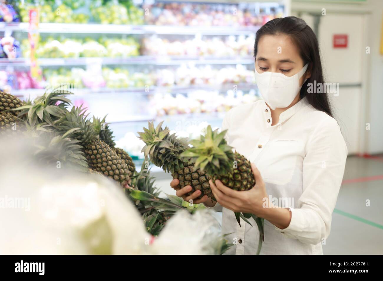 Asian woman long hair wearing protective face mask in supermarket ...