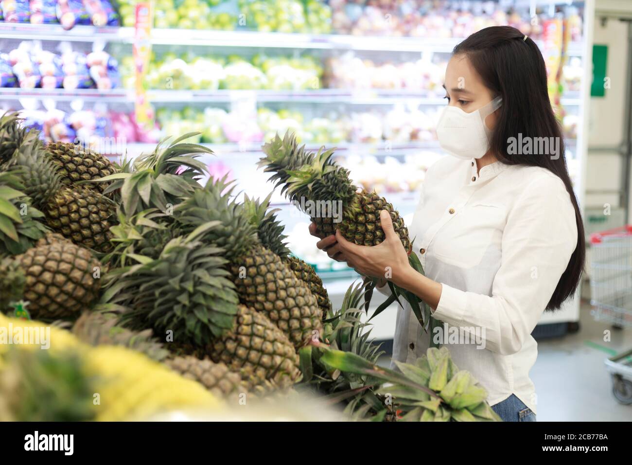 Asian woman long hair wearing protective face mask in supermarket ...