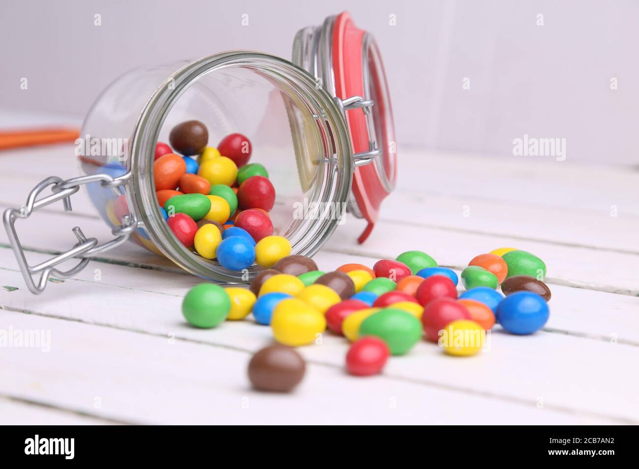 Colorful candles spilling out of a topple-over glass jar to a rustic ...
