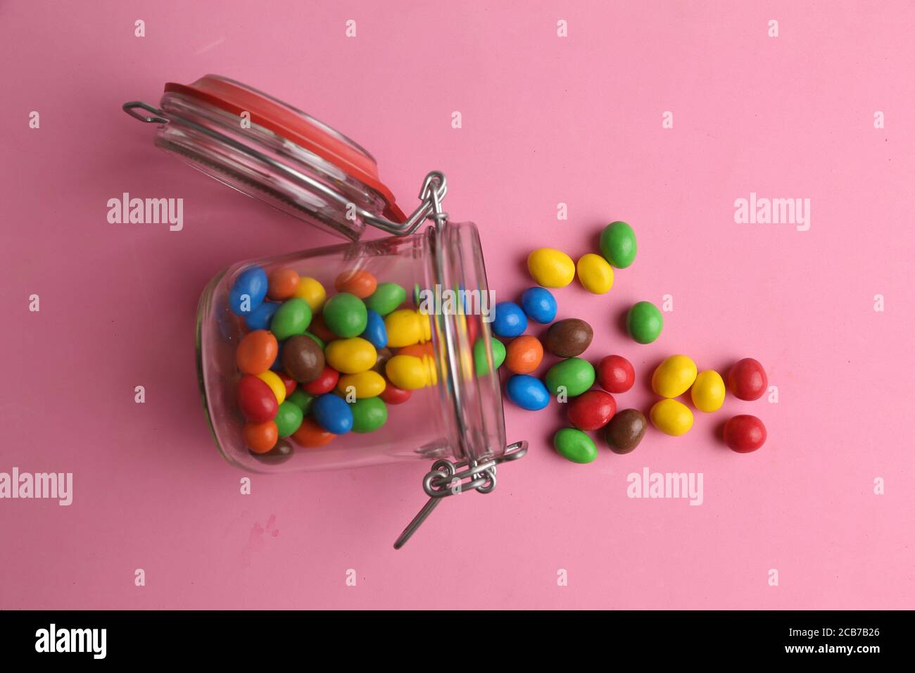 Colorful chocolate balls in a glass jar on a pink background Stock ...