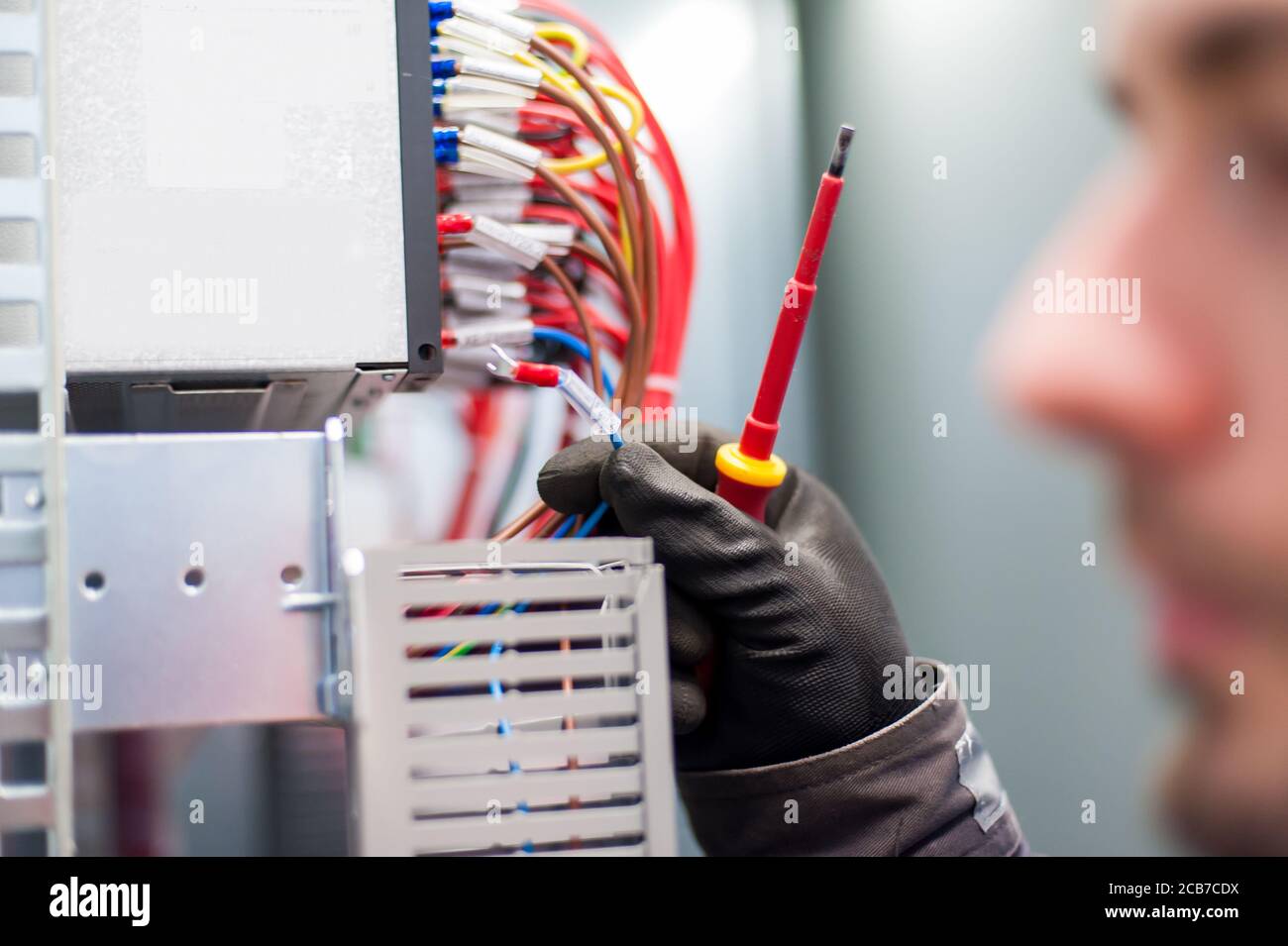 Closeup of electrician engineer works with electric cable wires of fuse ...