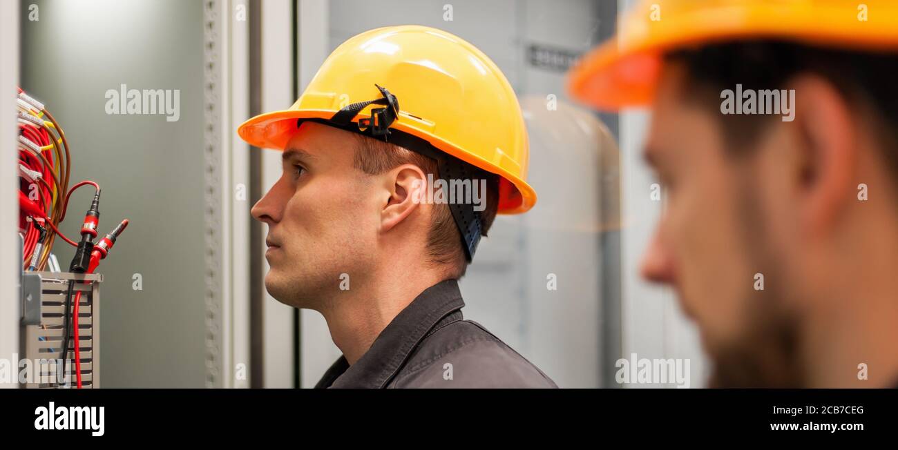 Closeup of electrician engineer works with electric cable wires of fuse ...