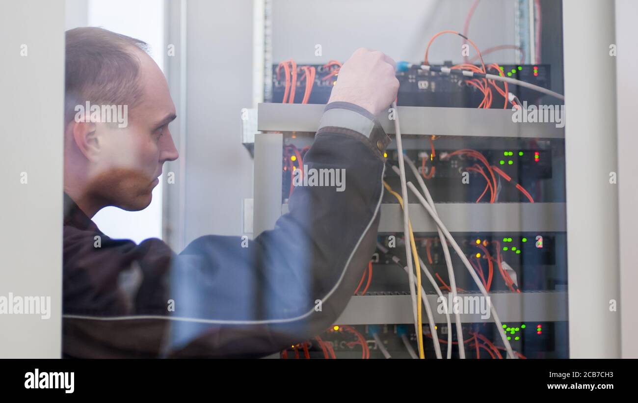 Electrician engineer tests electrical installations and wires on relay ...