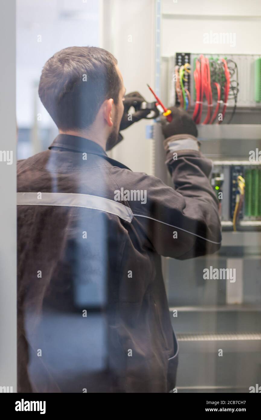 Electrician engineer tests electrical installations and wires on relay ...