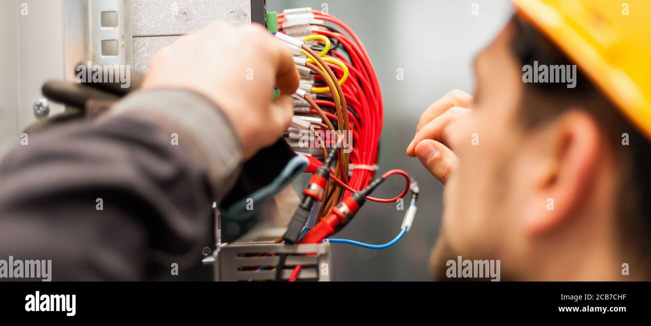 Electrician engineer tests electrical installations and wires on relay ...