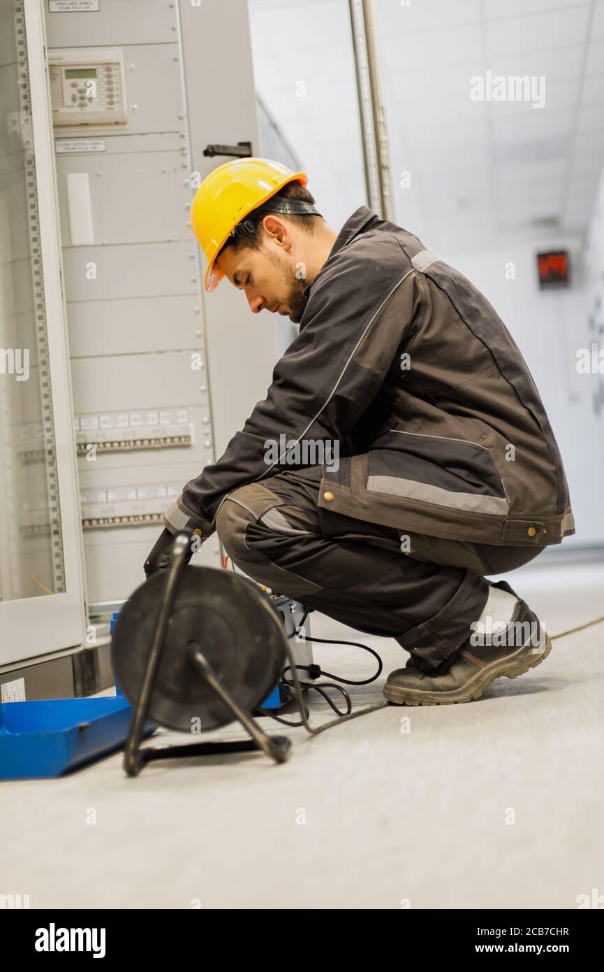 Electrician engineer tests system with relay test set equipment. Relay ...