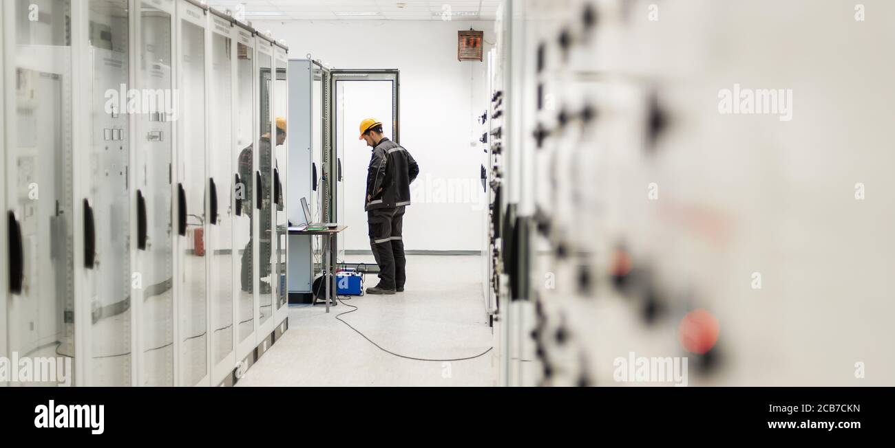 Engineer commissioning bay control unit. Engineering department. Medium ...