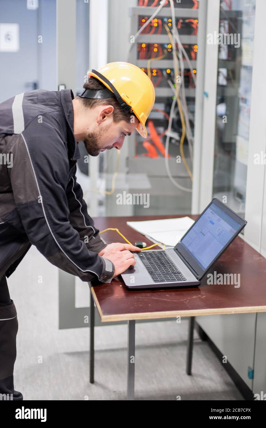 Field service engineer inspect relay protection system with laptop ...