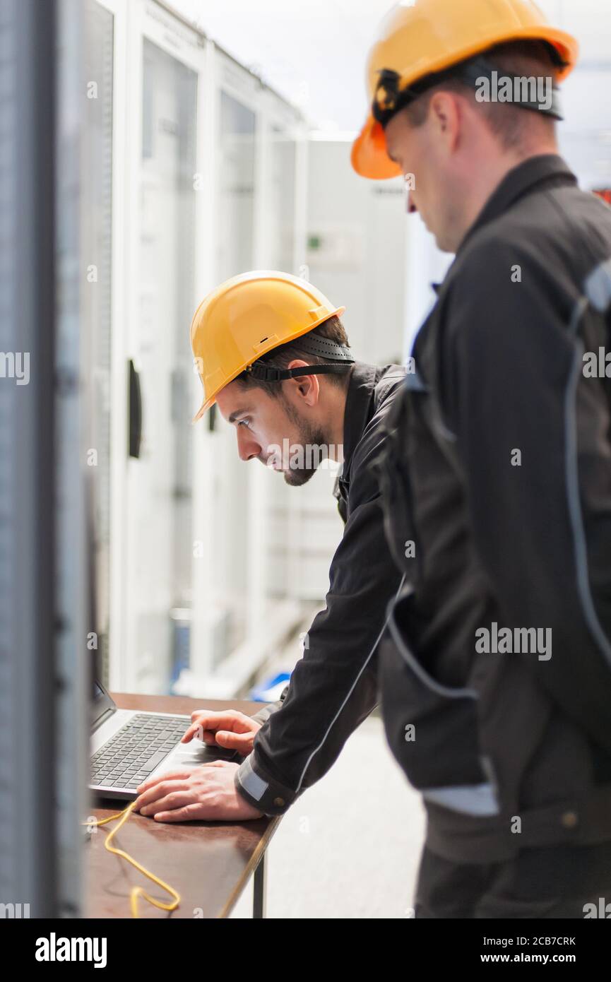 Field service crew engineers inspect relay protection system with ...