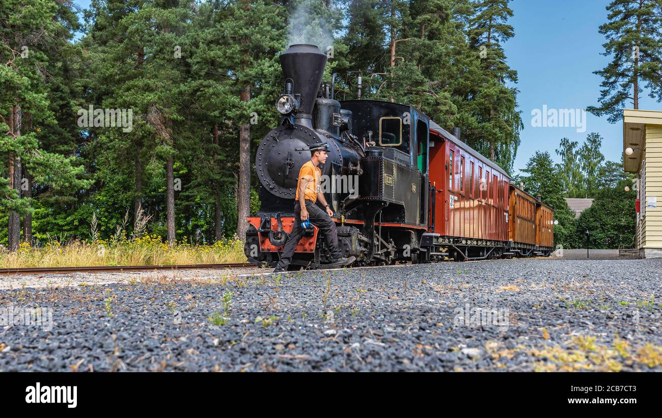 Old train with train driver with an oil jug that he lubricates the ...