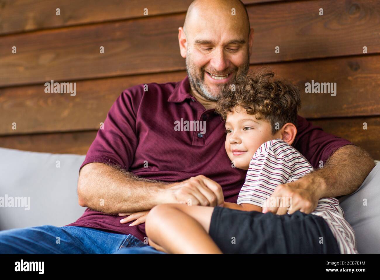 Hispanic father sitting and hugging his son Stock Photo - Alamy