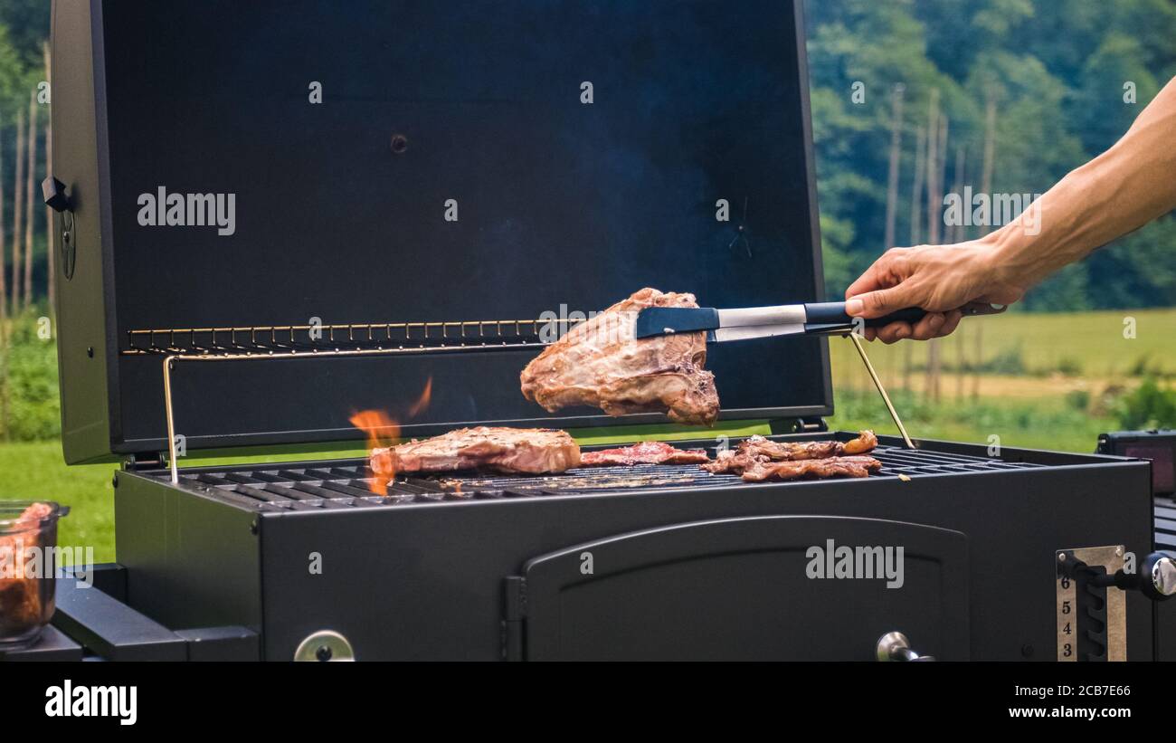 Home barbecue with charcoal in the backyard grilling steaks and other ...