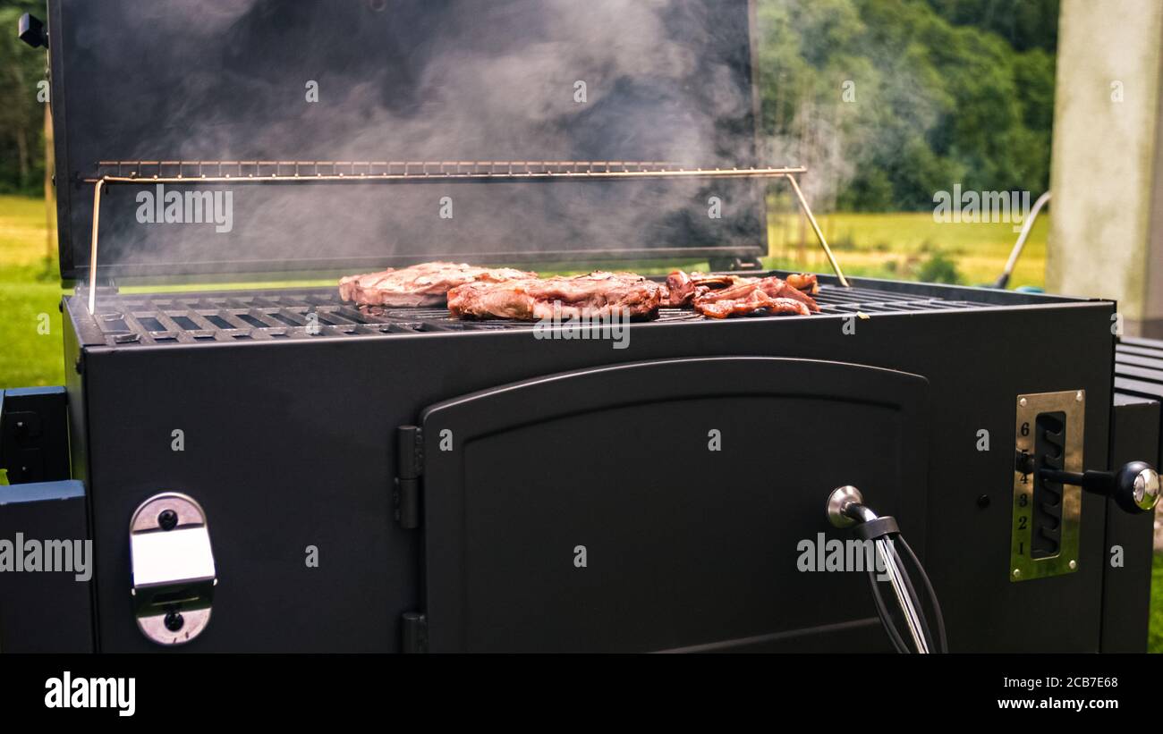 Home barbecue with charcoal in the backyard grilling steaks and other ...