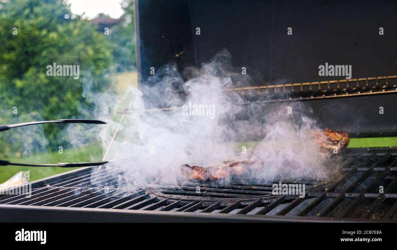 Home barbecue with charcoal in the backyard grilling steaks and other ...
