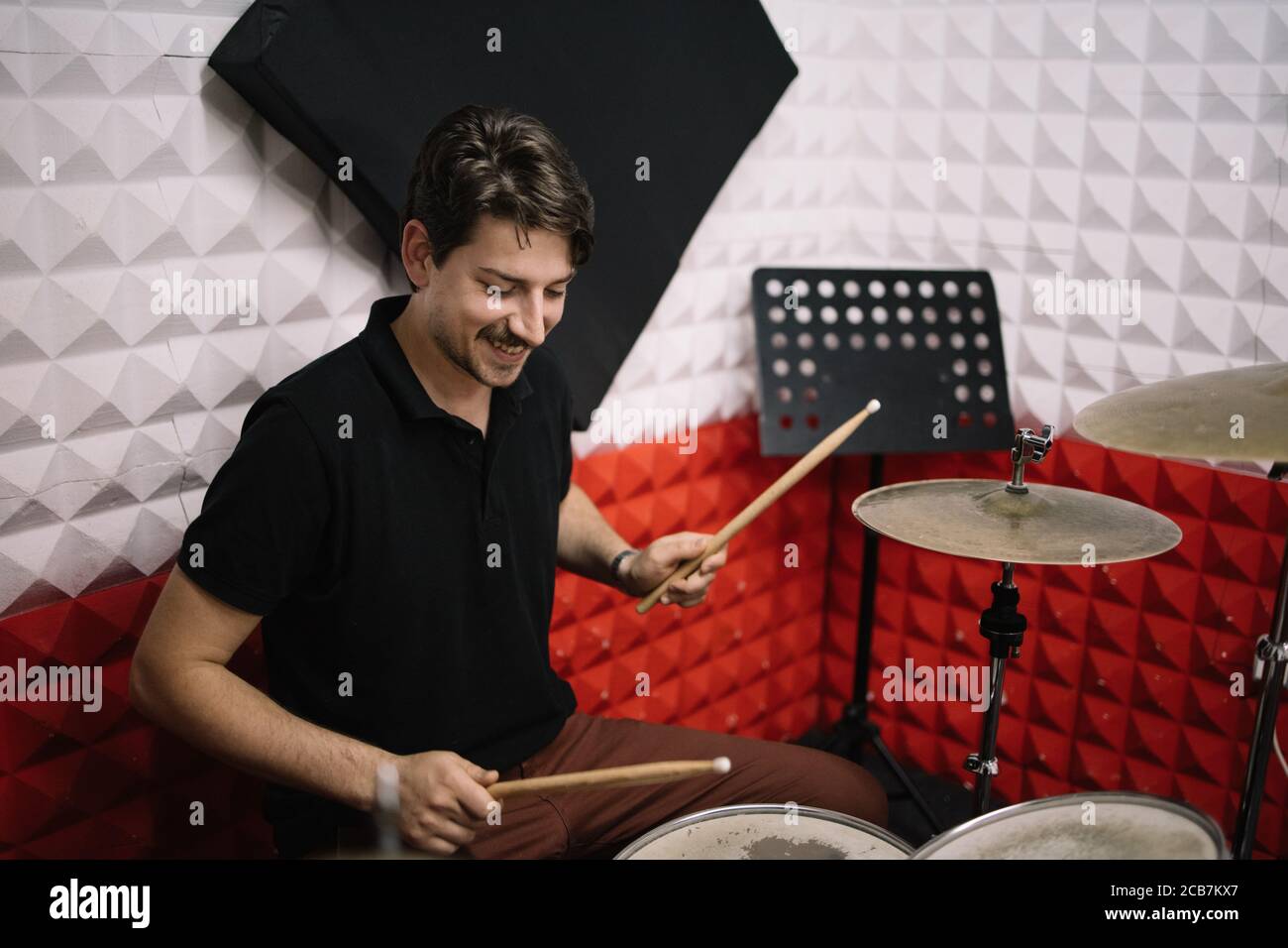 Young attractive man drummer playing drums and cymbals. Smiling male ...