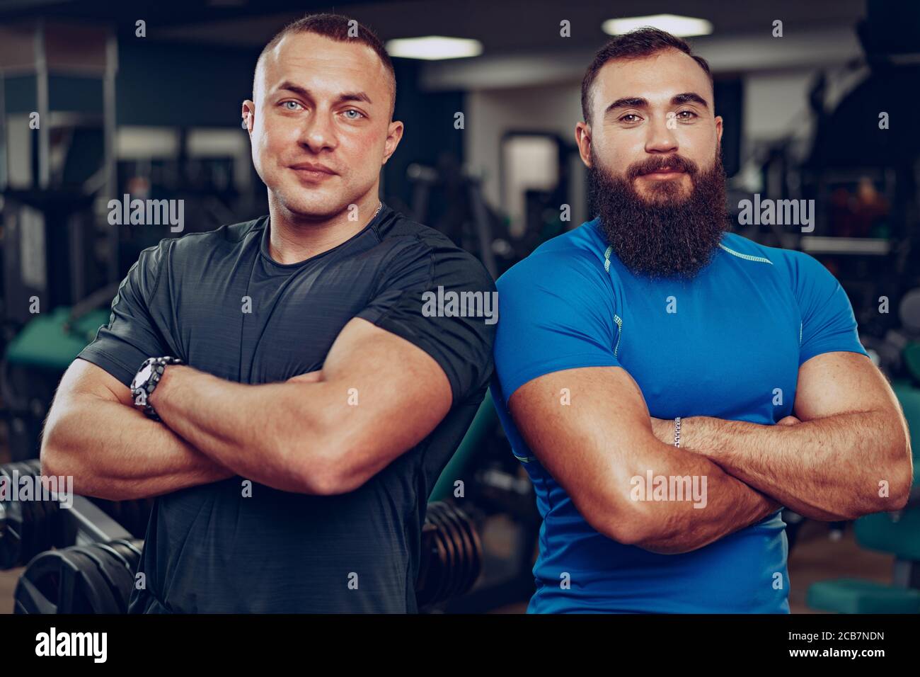 Two smiling fit men bodybuilders standing side to side in a gym Stock ...