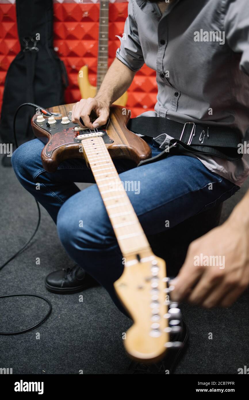 Cropped guitar player setting tone to his music instrument Stock Photo ...