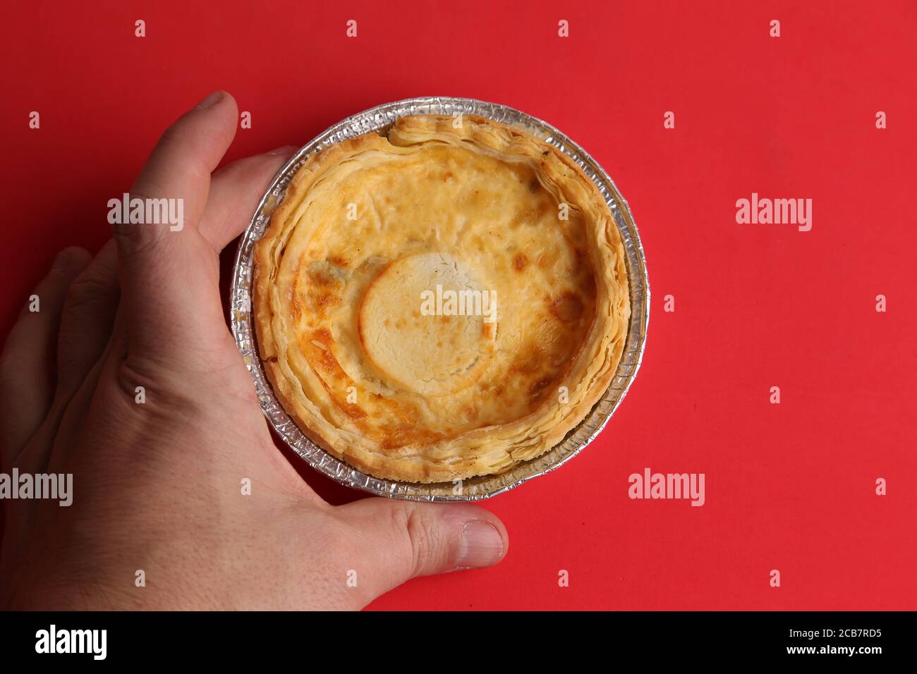 Top view of a hand golding meat pie isolated on a red background Stock ...