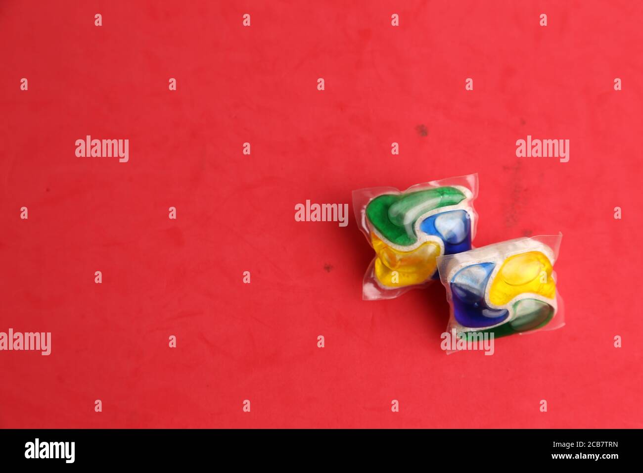 Soap capsules isolated on a red background Stock Photo - Alamy
