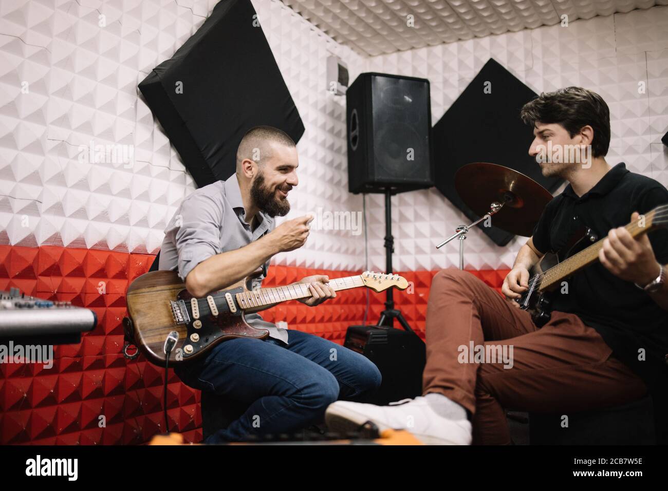 Smiling guitar players rehearsing in soundproof studio Stock Photo - Alamy