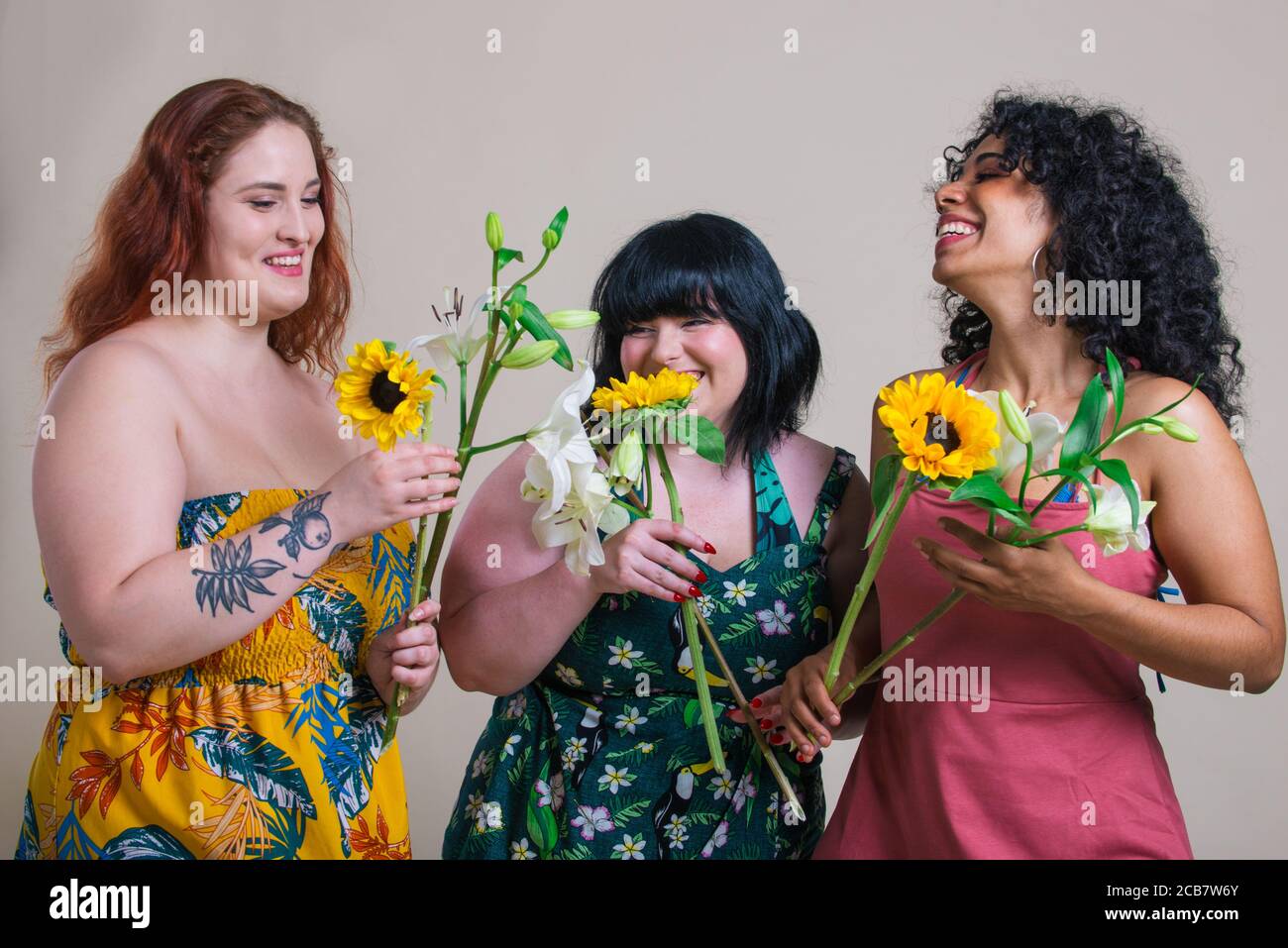 Plus size women making party. Curvy multiethnic girls wearing dresses ...