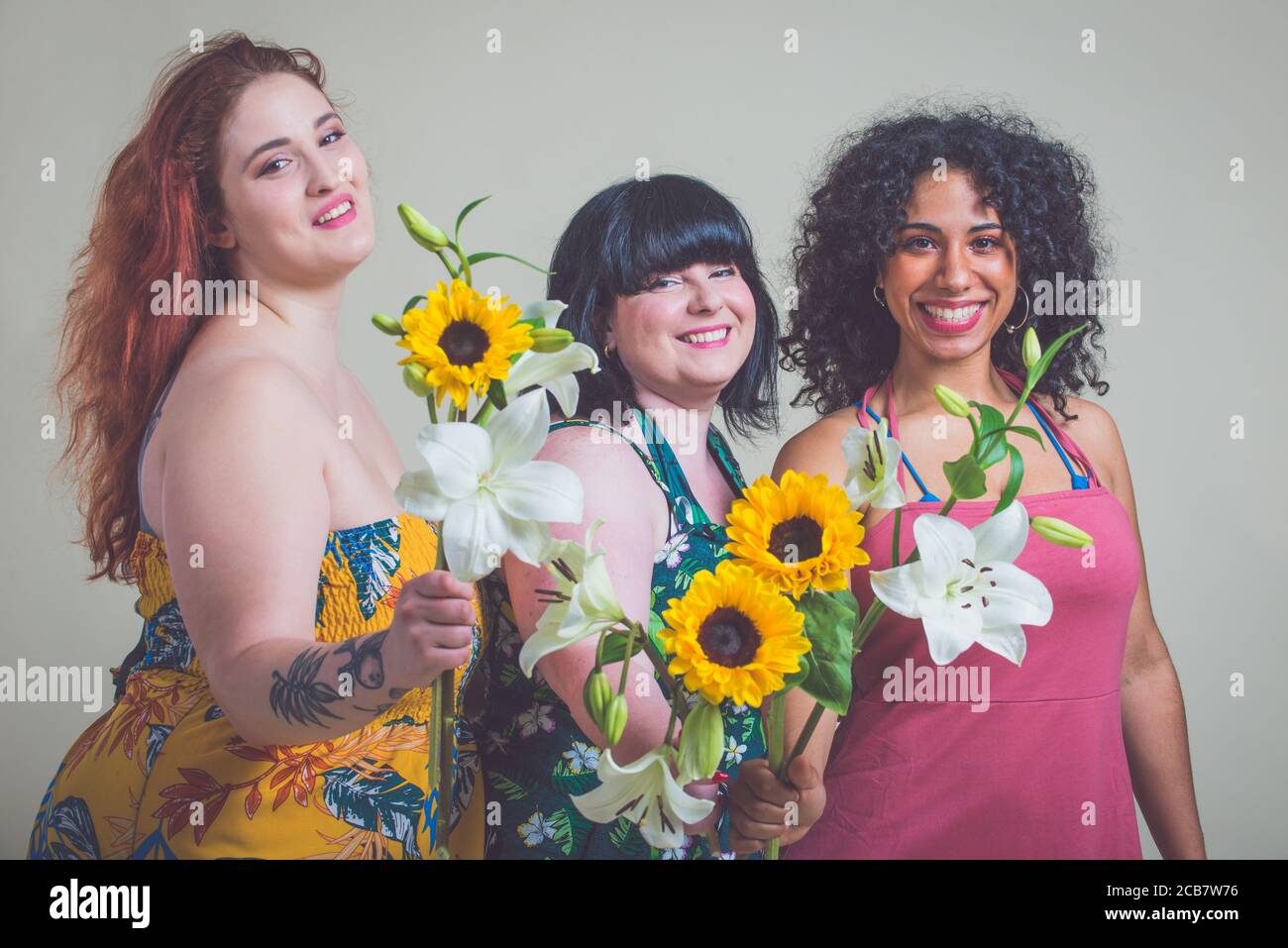 Plus size women making party. Curvy multiethnic girls wearing dresses ...