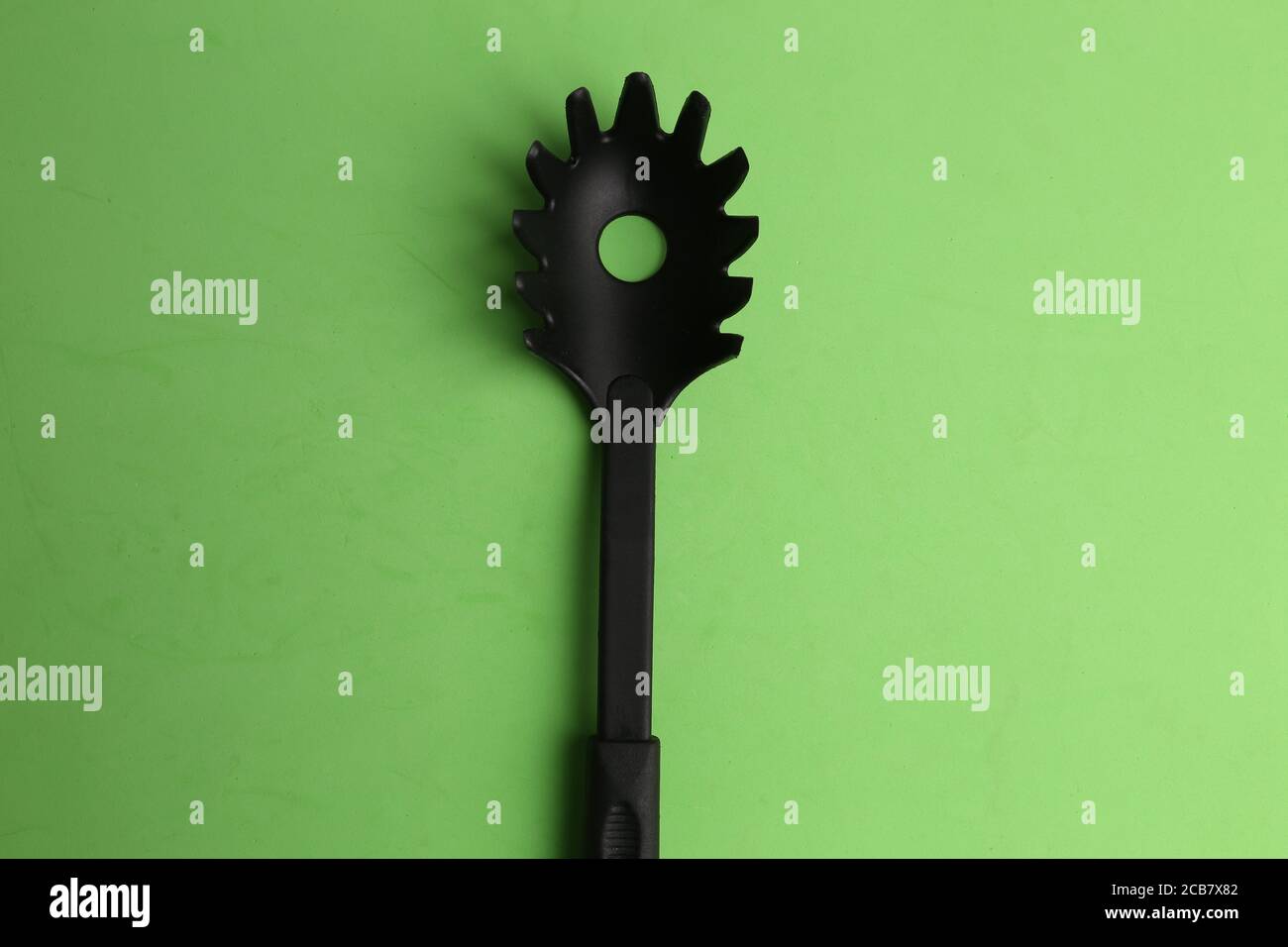 High angle closeup shot of a spaghetti spoon on a green background ...