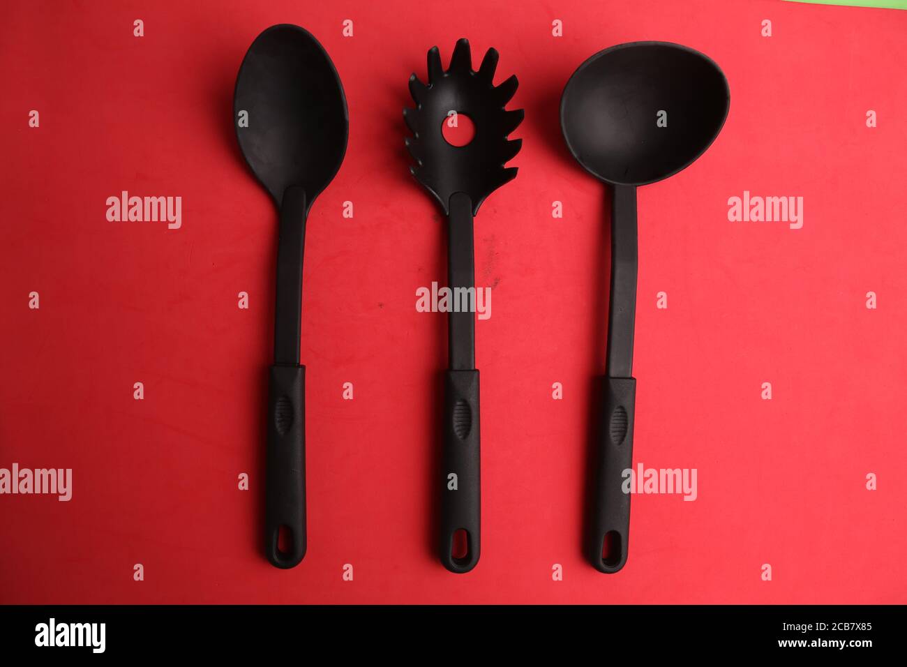 High angle closeup shot of three different black plastic ladles on a ...