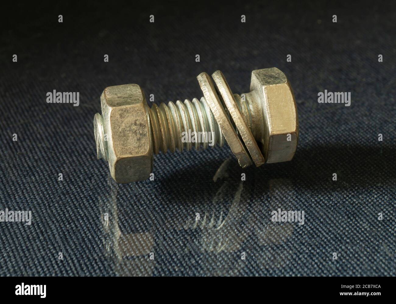 The Bolt with thread by nut and puck on table with reflection.Detail ...