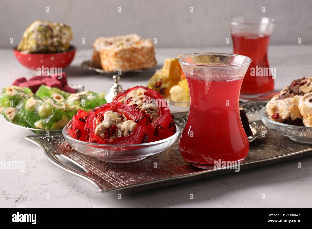 Turkish delight and pomegranate tea on metal tray on gray background ...